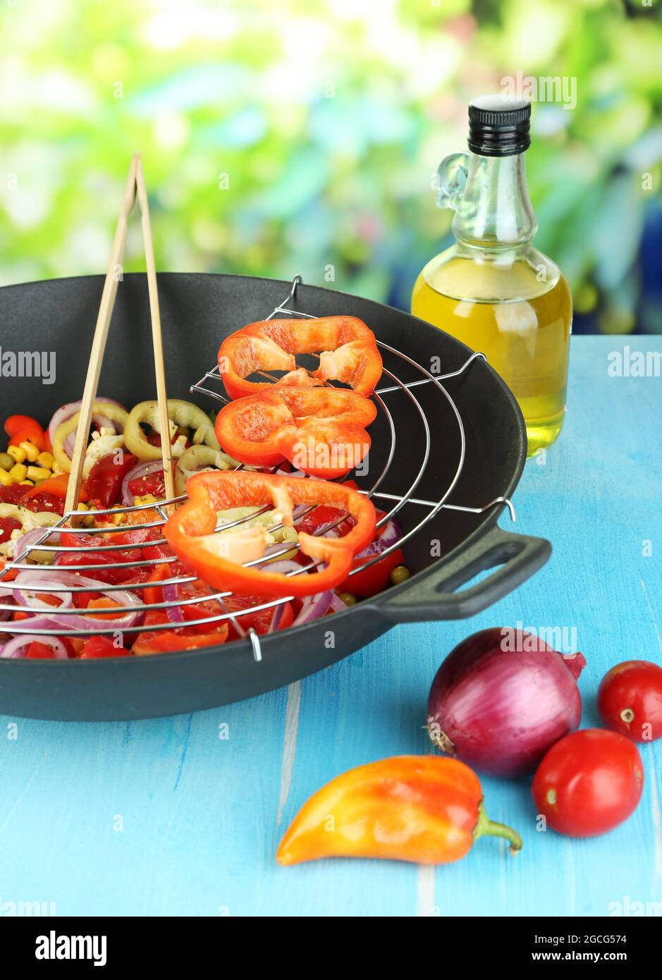 Vegetables in wok on wooden table on natural background Stock Photo - Alamy
