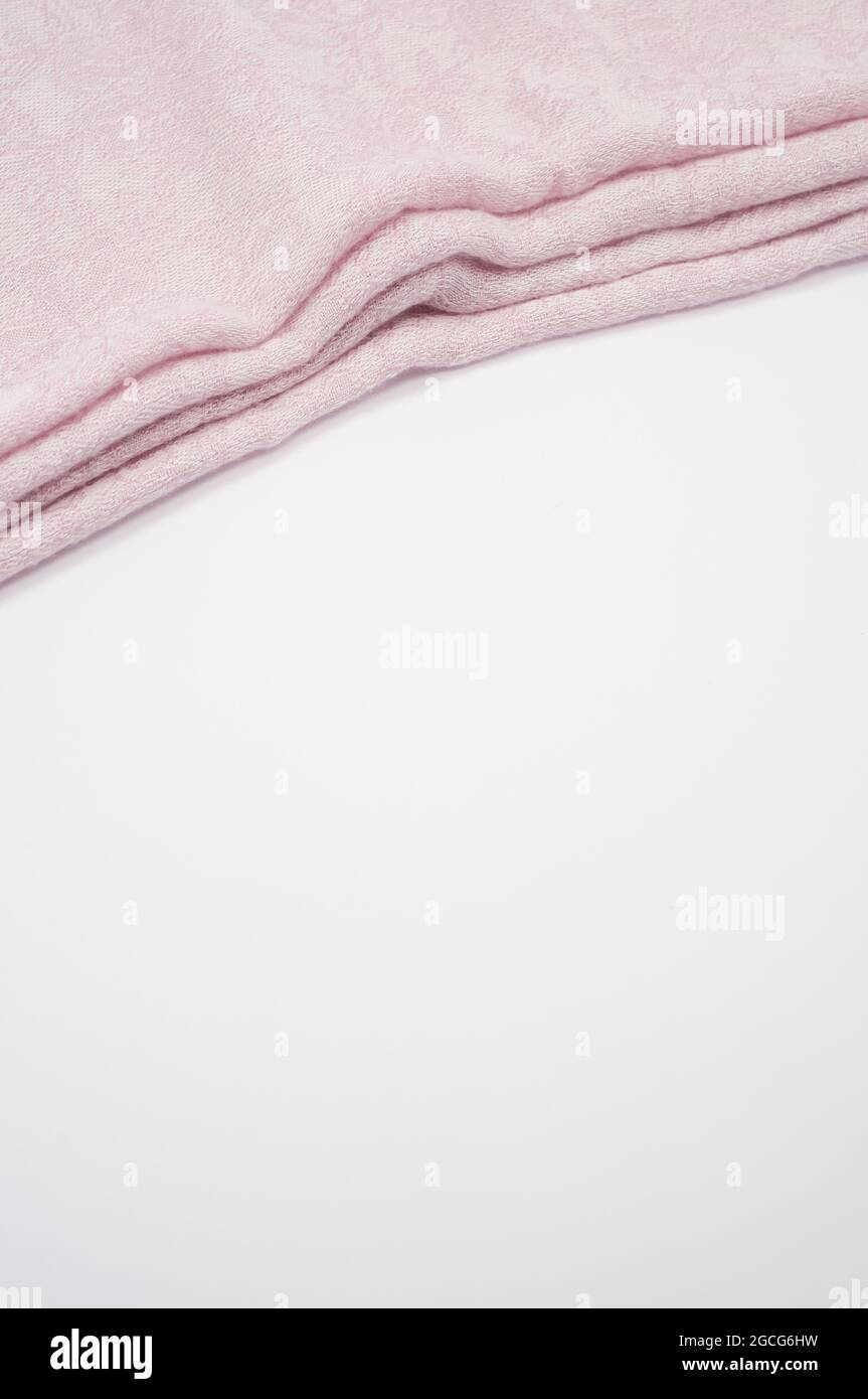 A closeup shot of a folded pale pink scarf isolated on white with a ...