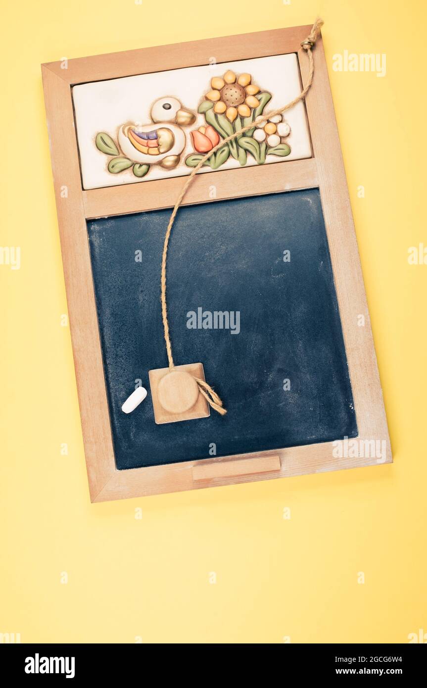A top view of a small wall chalkboard for schedules on yellow ...