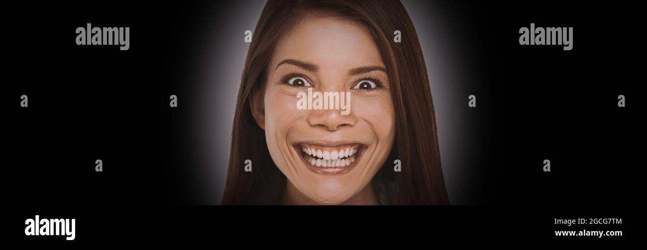 Scary face expression of crazy Asian girl with evil smile on black ...