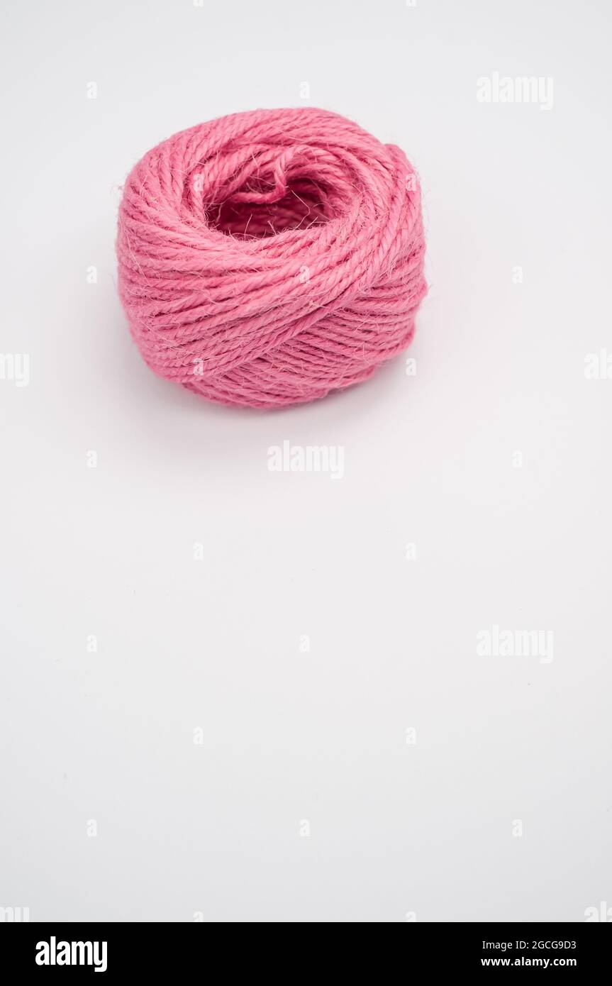 A top view of a single soft pink textile ball of wool on a white ...