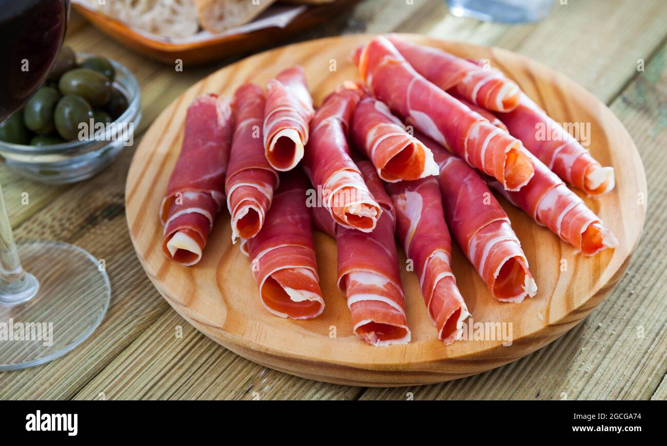 Rolled up slices of dry-cured ham Stock Photo - Alamy
