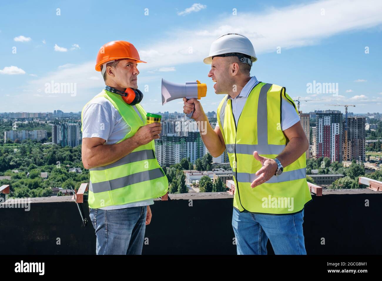 Angry boss yelling in megaphone at his builder on construction site ...