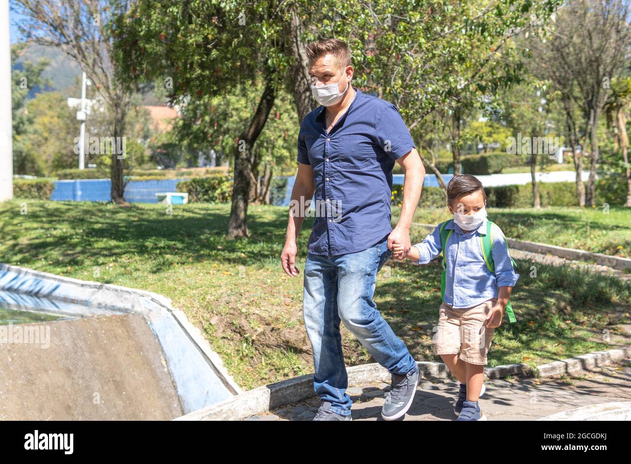 Father leading his preschool son by the hand to kindergarten Stock ...
