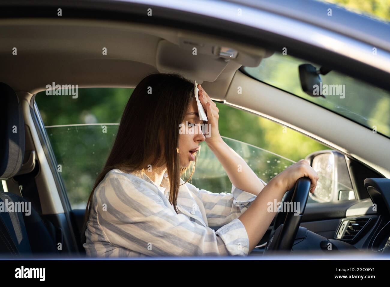 Woman driver being hot during heat wave in car, suffering from hot ...