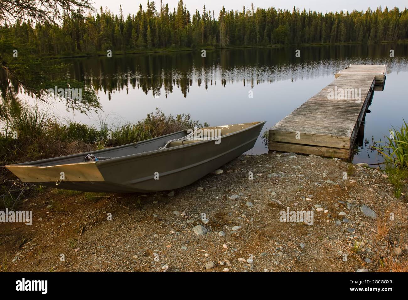 dock in lake water near forest with boat Stock Photo - Alamy
