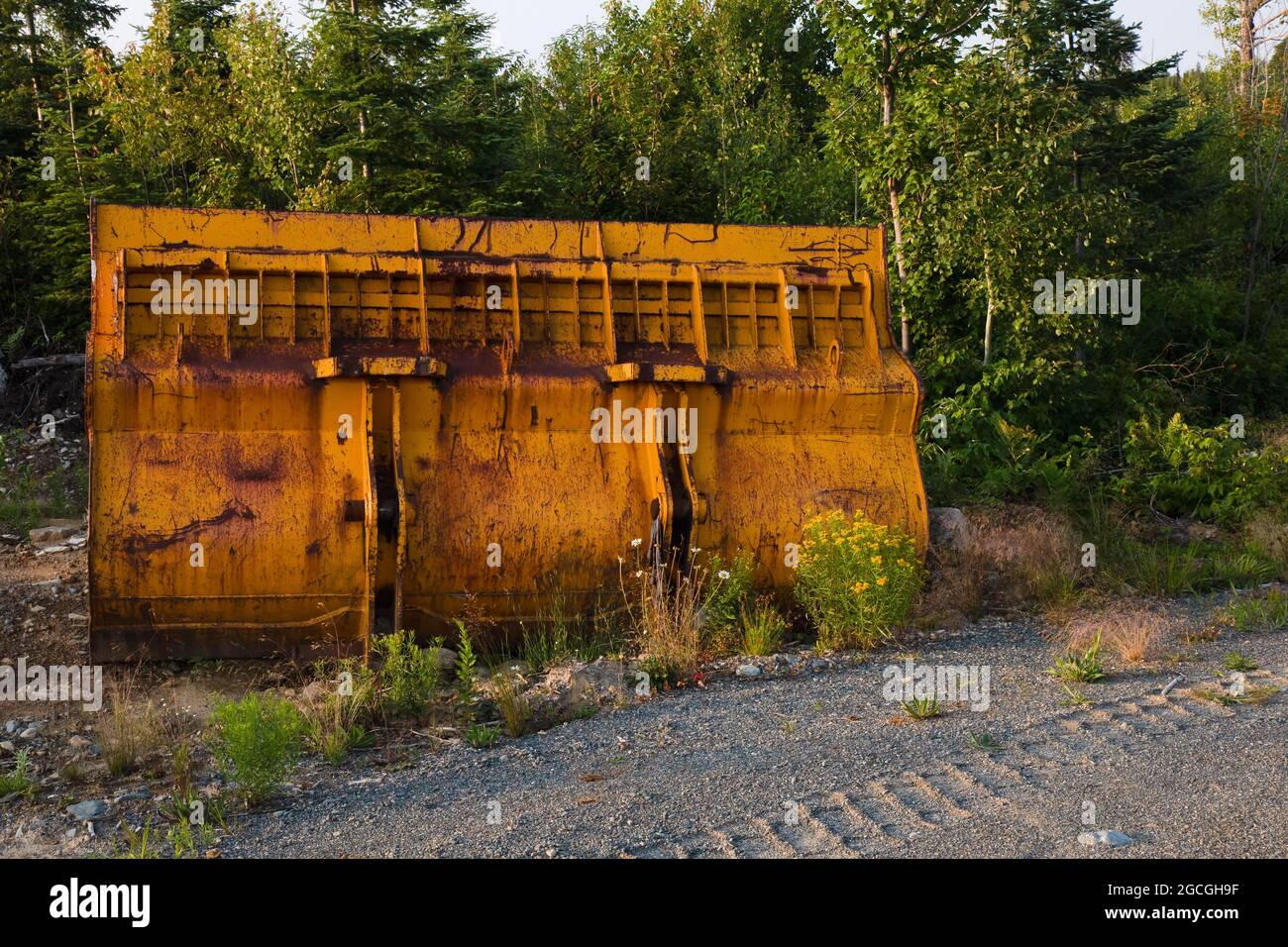 old loader bucket on side of gravel road Stock Photo - Alamy