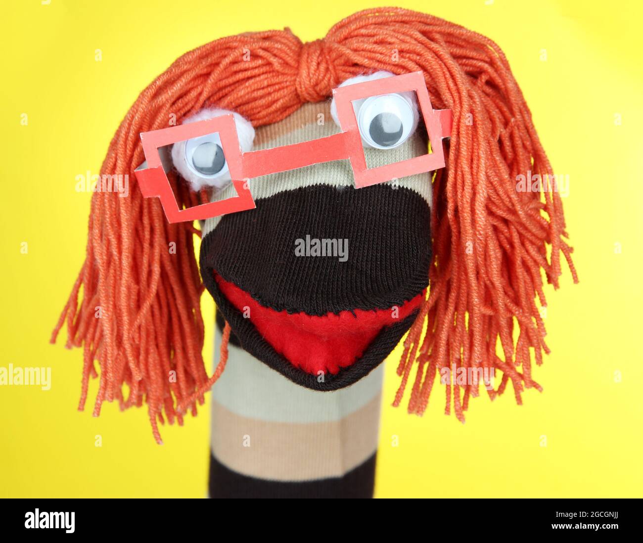 Cute sock puppet on yellow background Stock Photo - Alamy