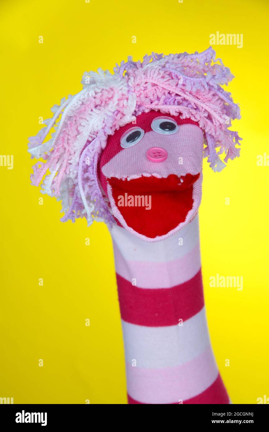 Cute sock puppet on yellow background Stock Photo - Alamy