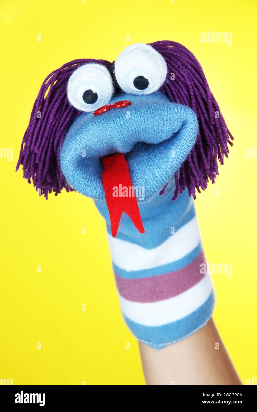 Cute sock puppet on yellow background Stock Photo - Alamy