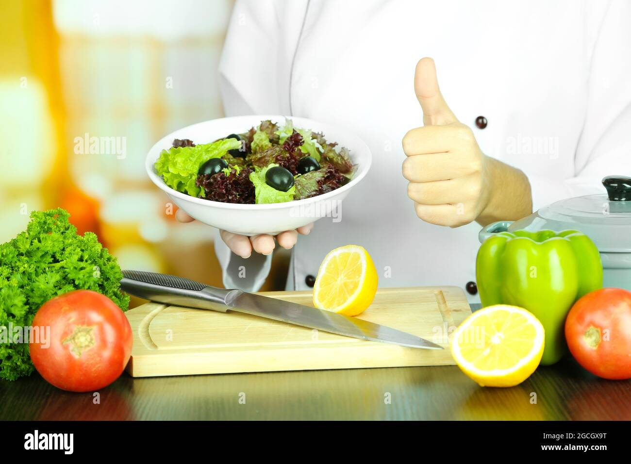 Cook hands holding plate of salad Stock Photo - Alamy