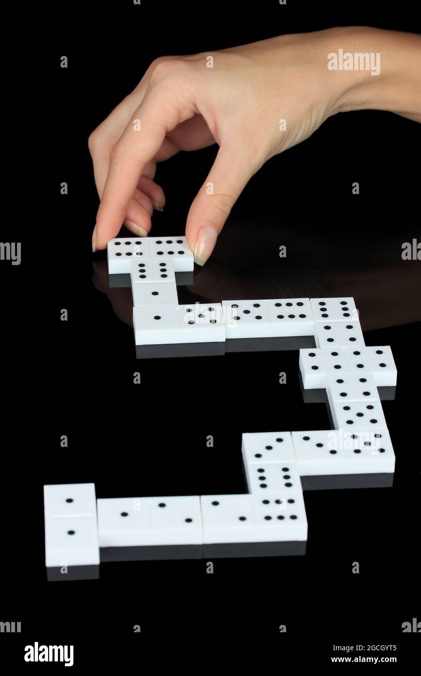Hand playing domino isolated on black Stock Photo - Alamy
