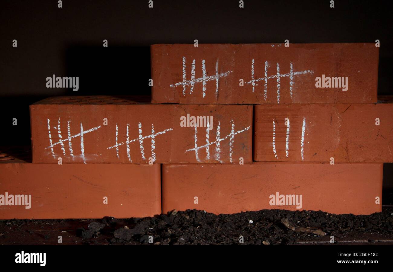 Counting days by drawing sticks on bricks on dark background Stock ...