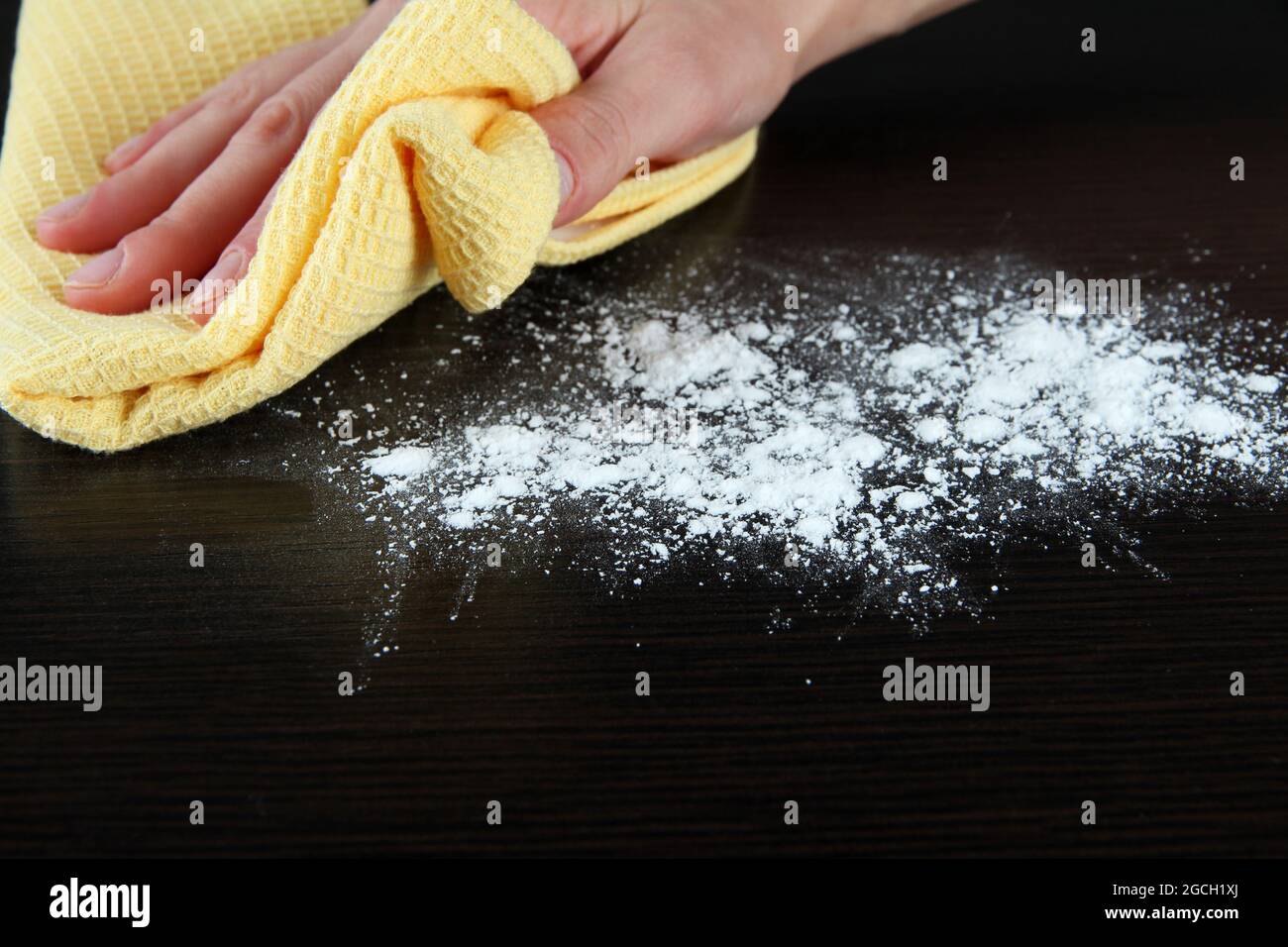 Hand wiping wooden surface with yellow rag Stock Photo - Alamy