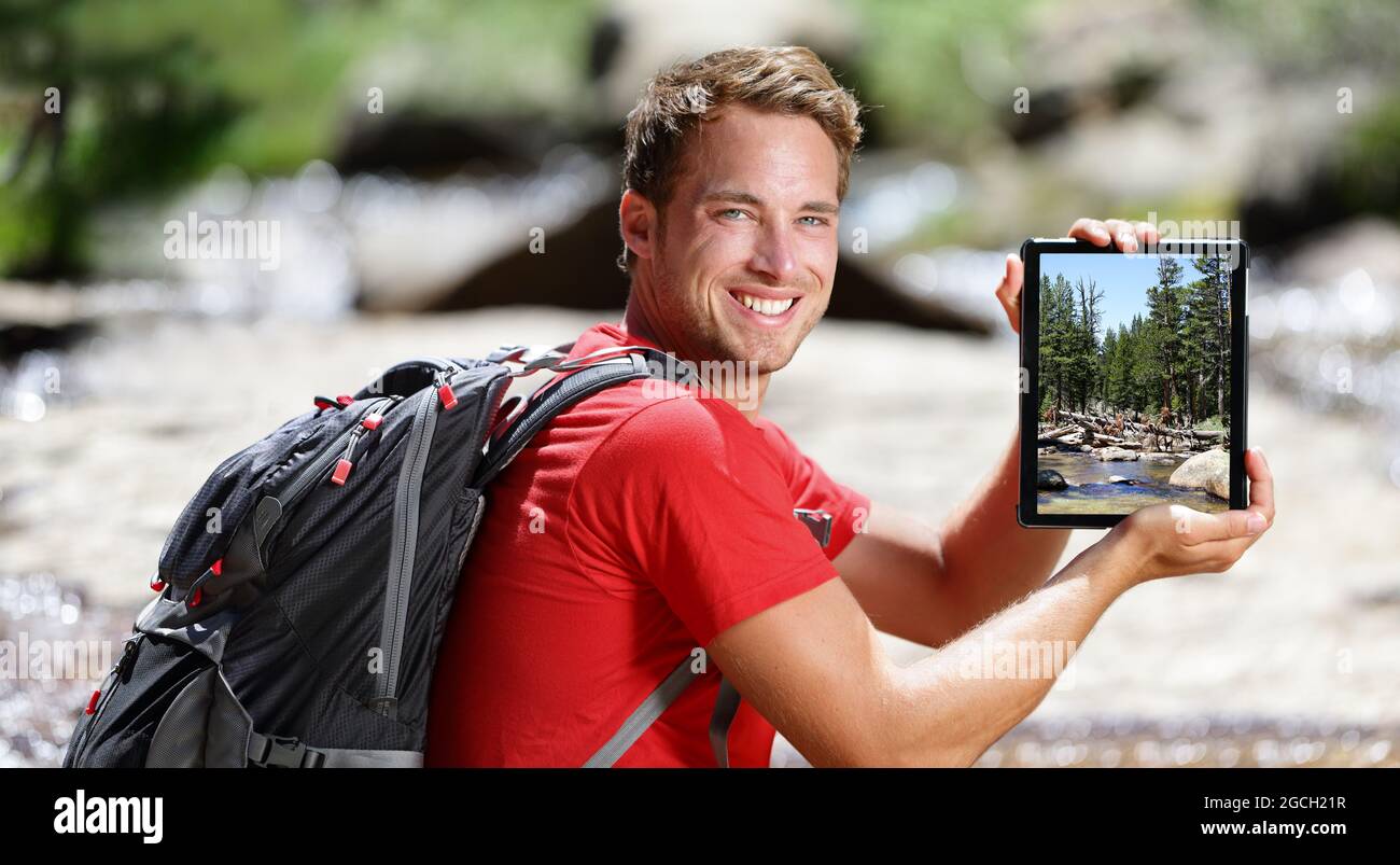 Tablet computer man hiker hiking in Yosemite, USA using travel app ...