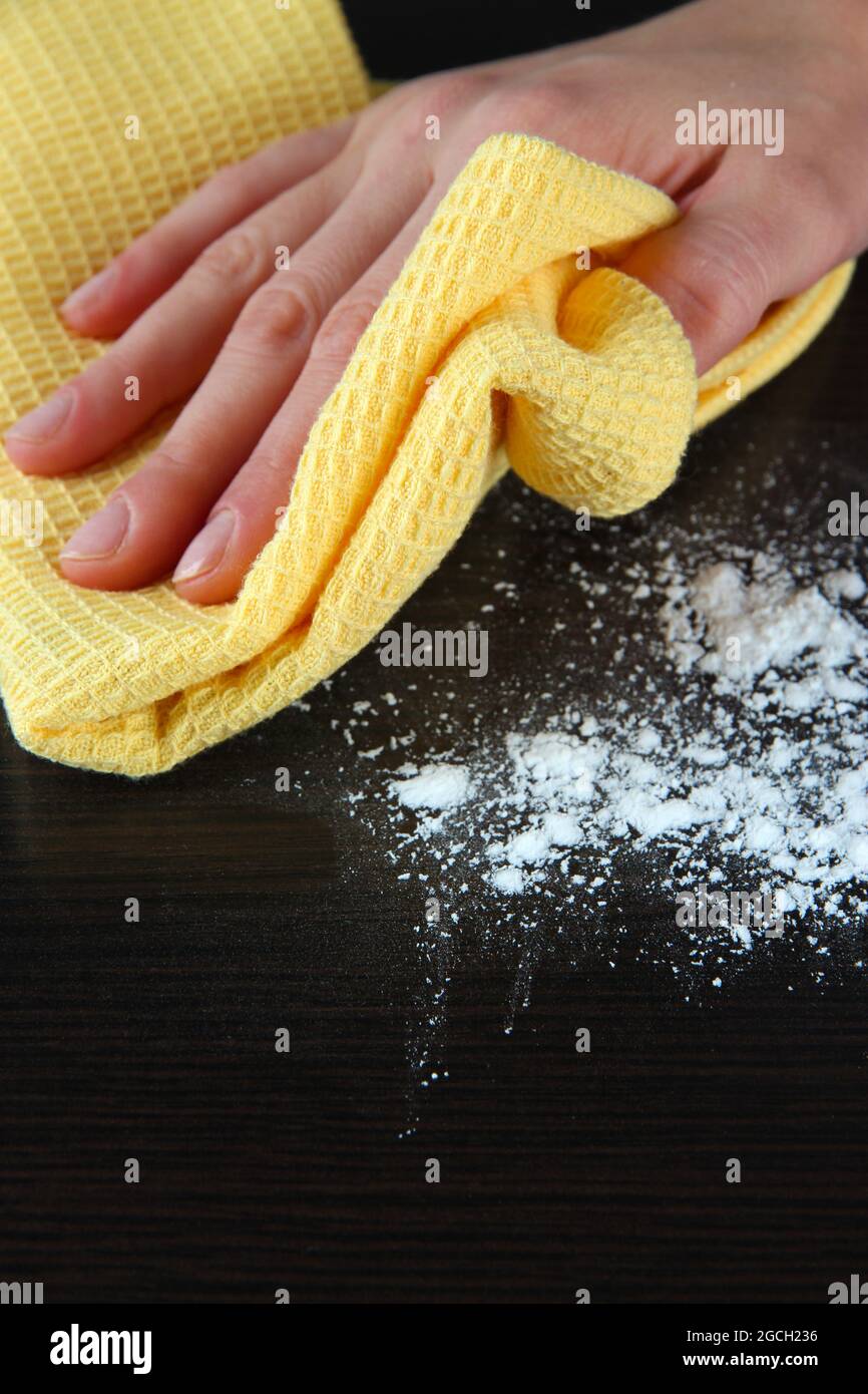 Hand wiping wooden surface with yellow rag Stock Photo - Alamy