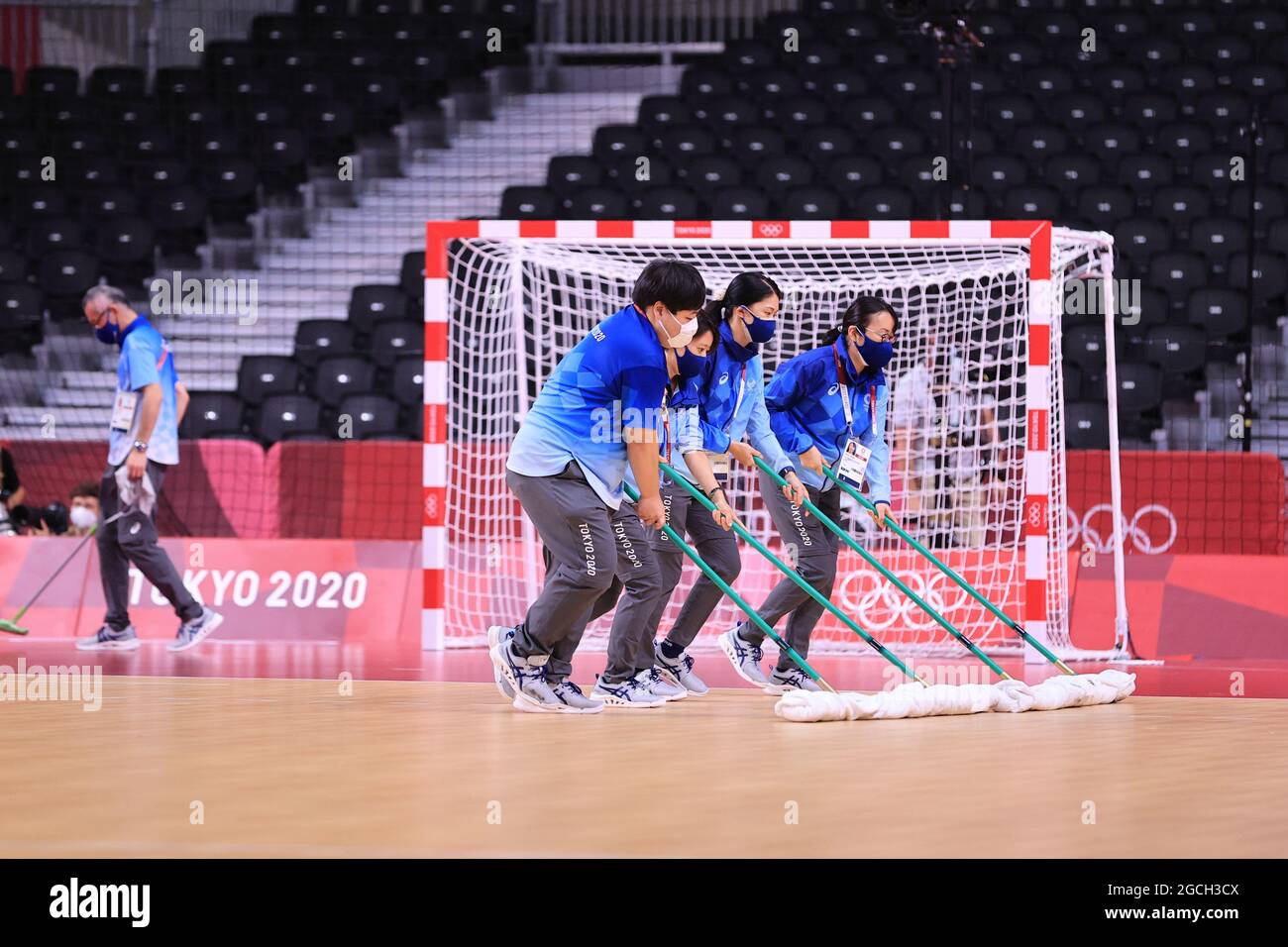 Volunteer staff clean the surface in a break in the Gold Medal March of ...