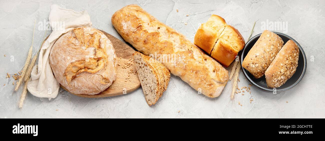 Various types of fresh baked bread on light gray background. Top view ...