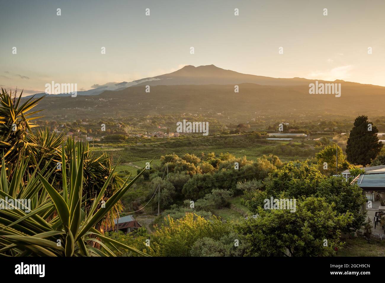 Sicilian rural landscape with Etna volcano eruption at sunset in Sicily ...