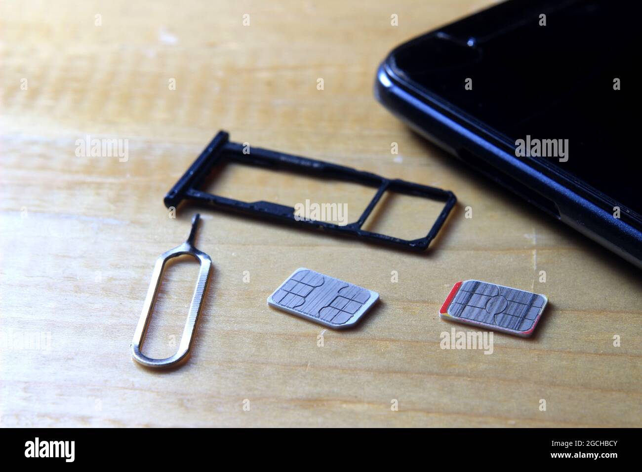 Sim CARD Ejector and Smartphone at Wooden Table Stock Photo - Alamy