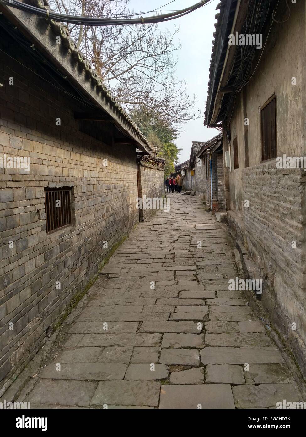 An ancient alleyway featuring a cobble stone road and old plaster house ...