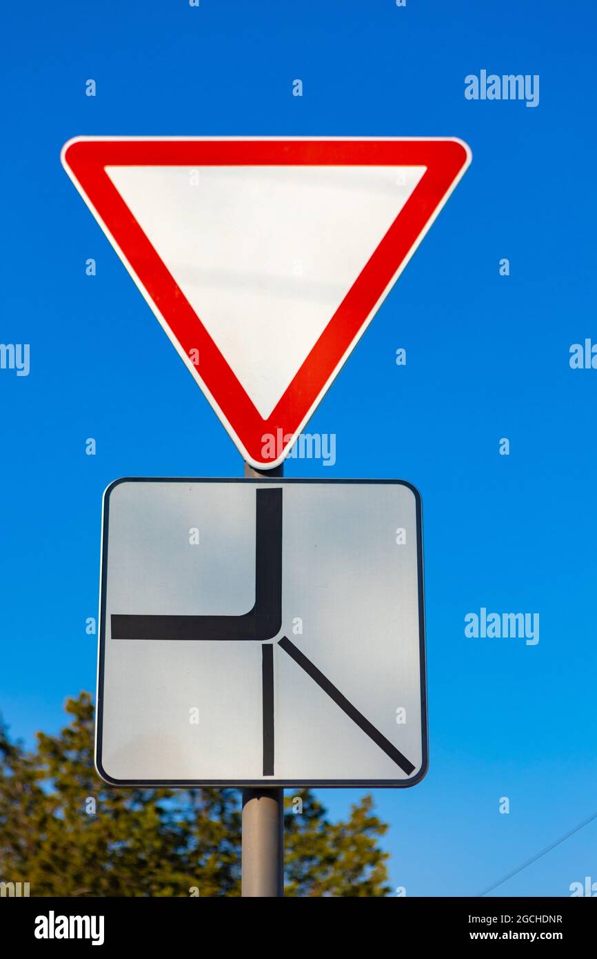 Give way traffic sign agaisnt blue sky Stock Photo - Alamy