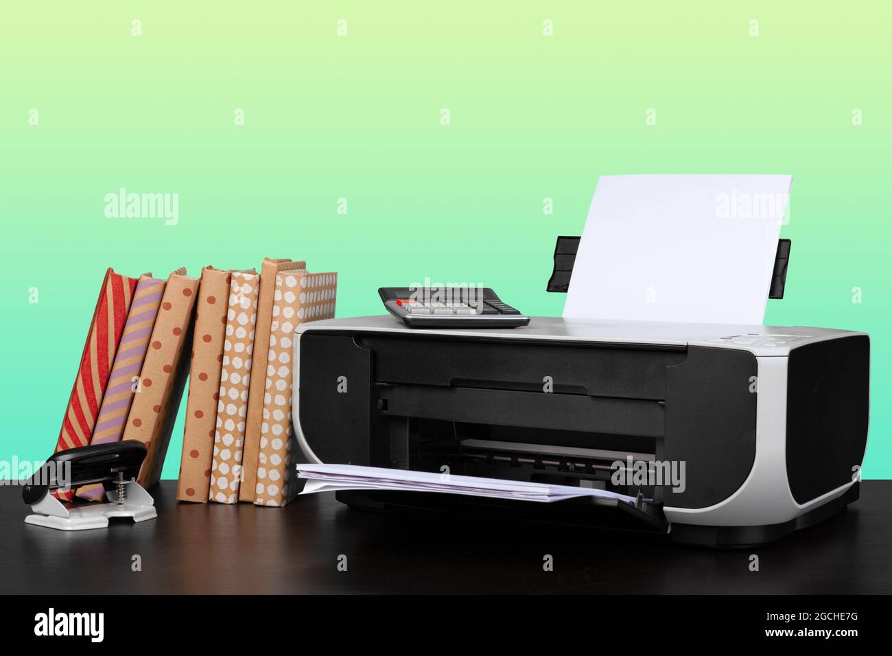 Home laser printer on desk against green background Stock Photo - Alamy