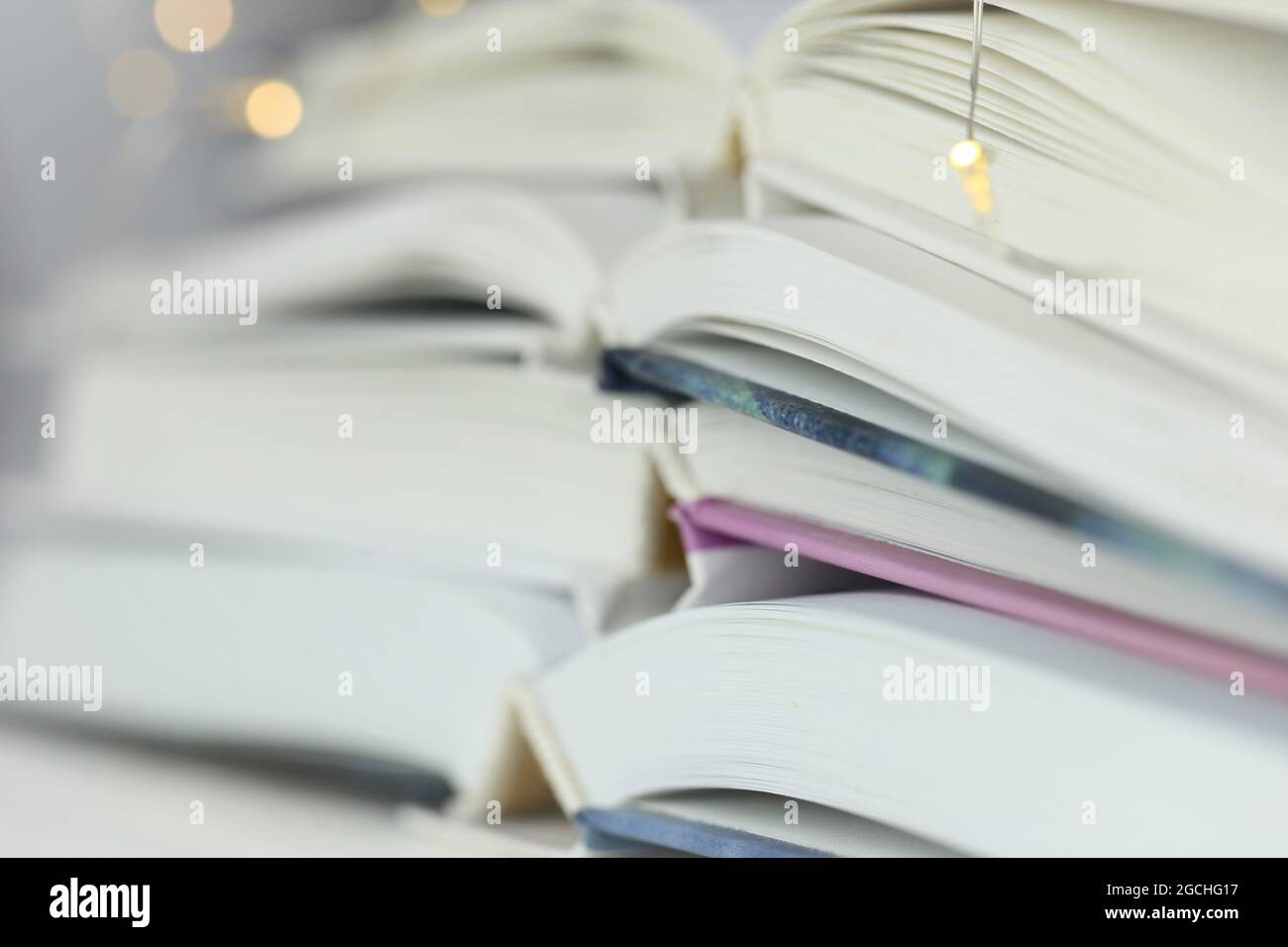 Reading of books. Books with white covers stack close-up and garland on ...