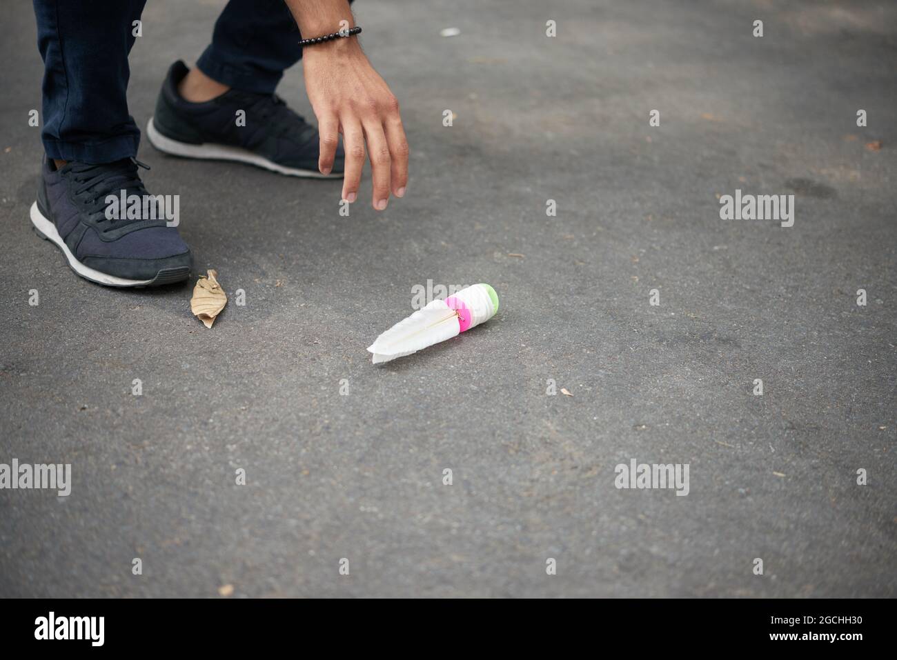 Man taking shuttlecock for Jianzi game from the asphalt road Stock ...