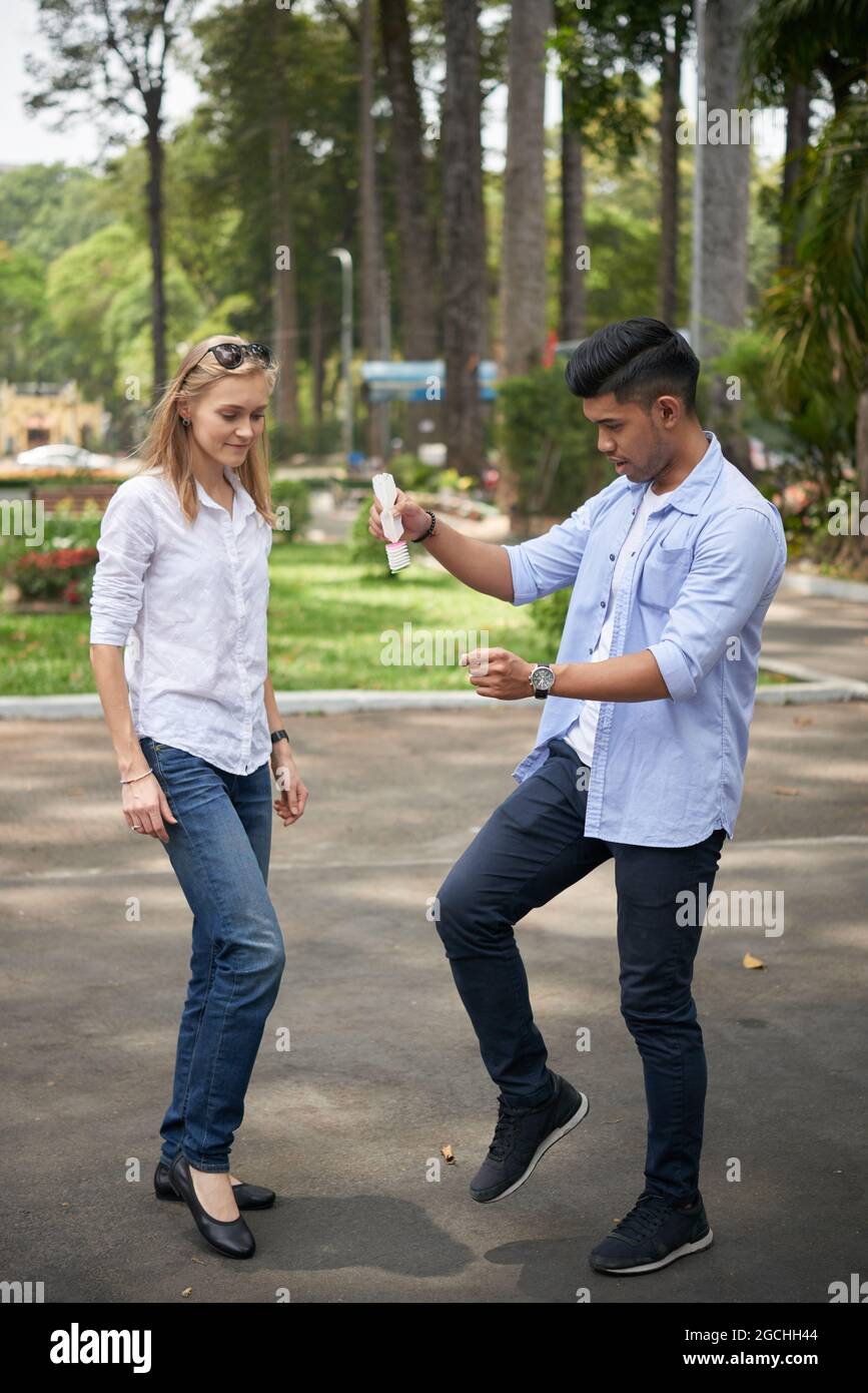 Young man explaining girlfriend how to play traditional Chinese Jianzi ...