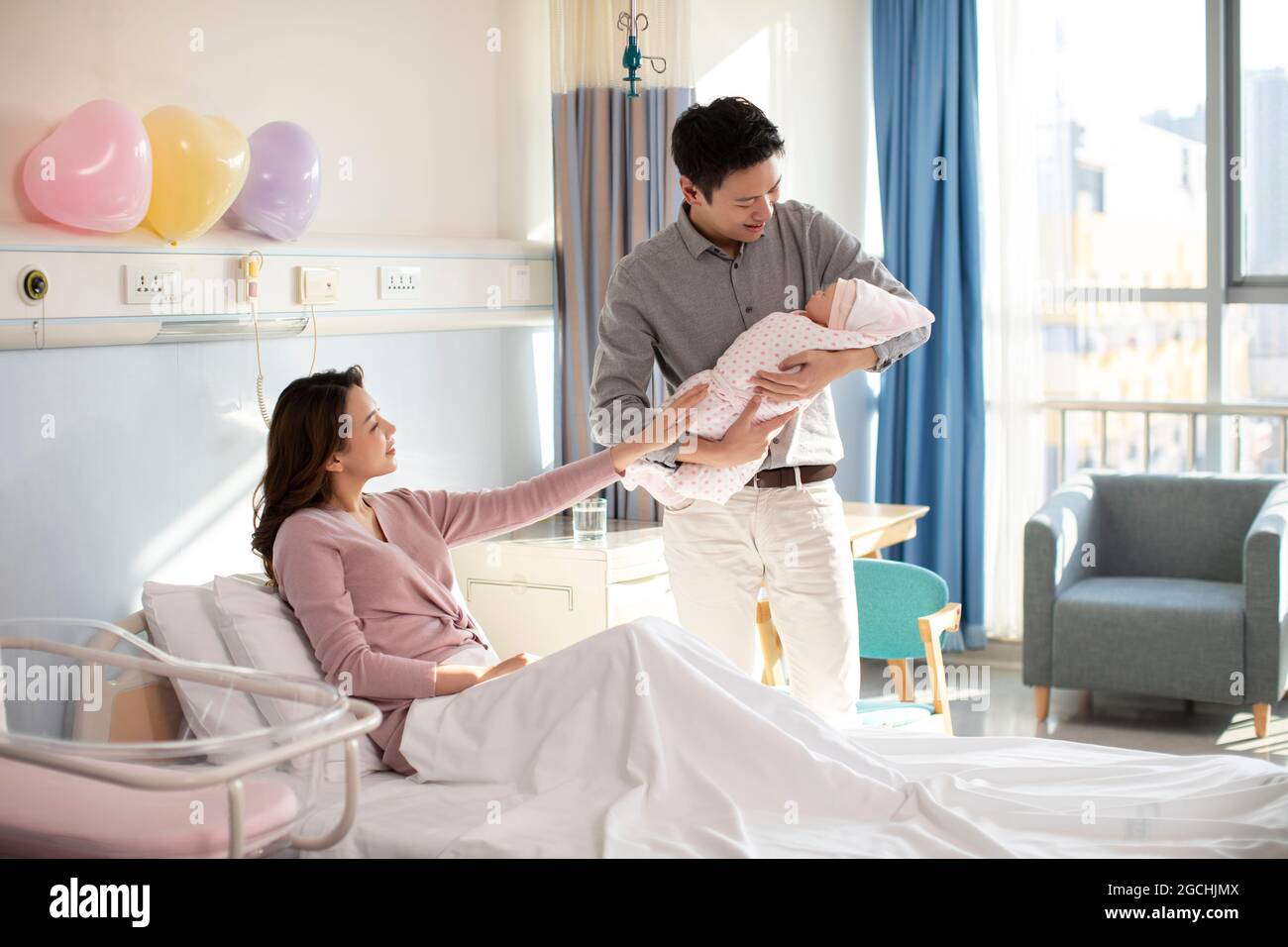 Parents with newborn baby in hospital ward Stock Photo - Alamy