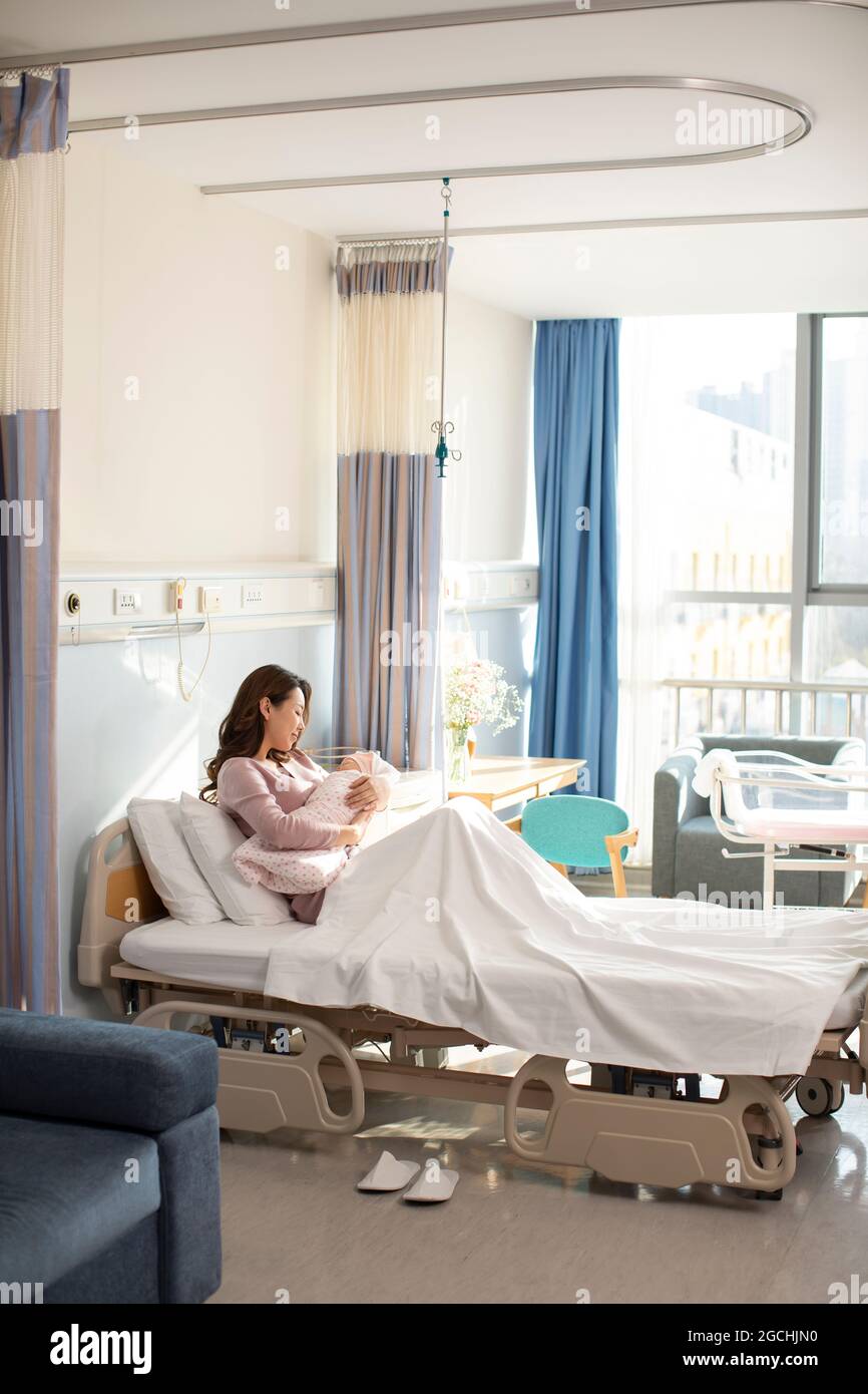 Young mother holding newborn baby in hospital ward Stock Photo - Alamy
