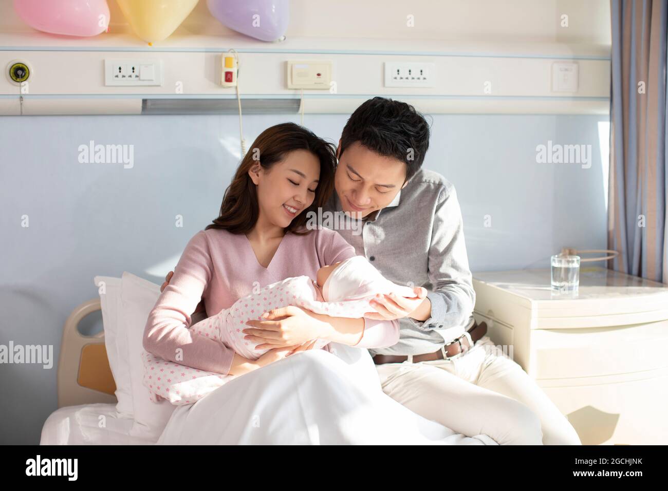Parents with newborn baby in hospital ward Stock Photo - Alamy