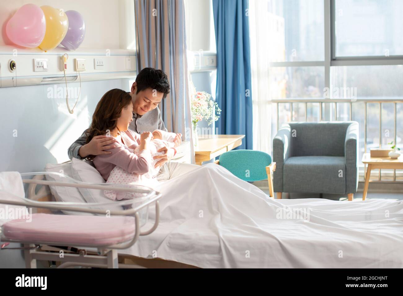 Parents with newborn baby in hospital ward Stock Photo - Alamy