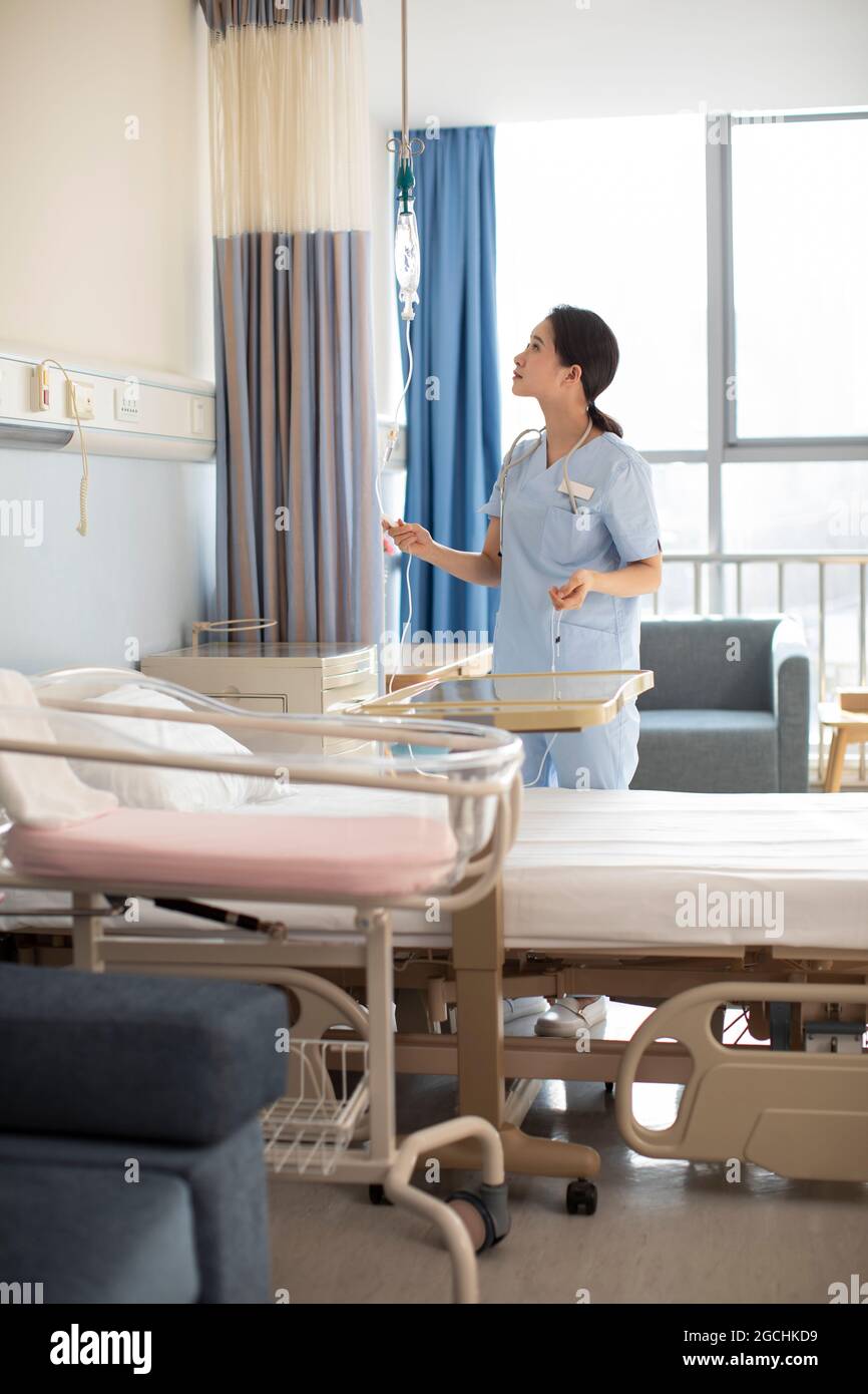 Young nurse checking IV drip in hospital ward Stock Photo - Alamy