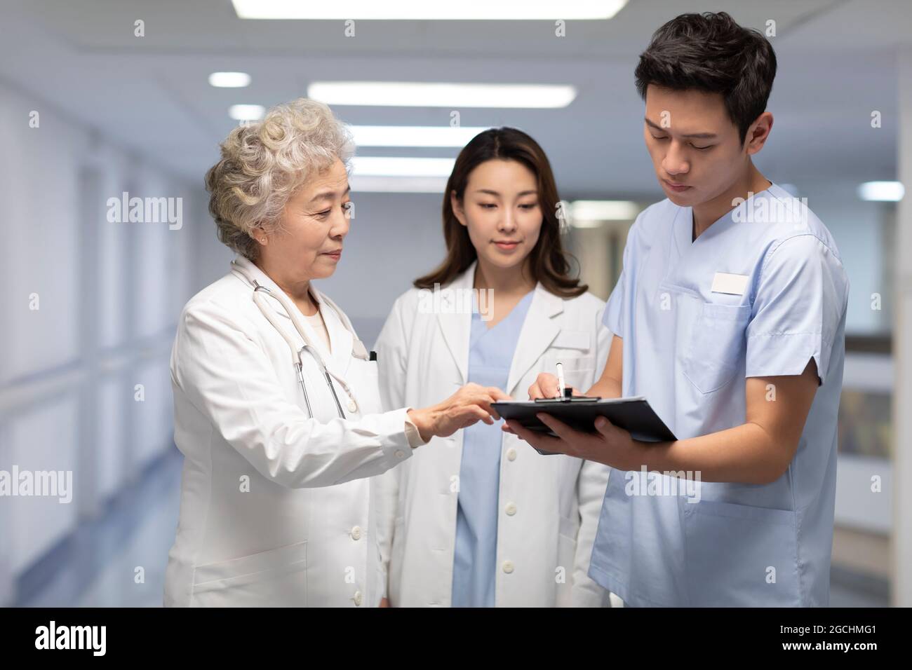 Male senior doctor standing in hospital corridor hi-res stock ...