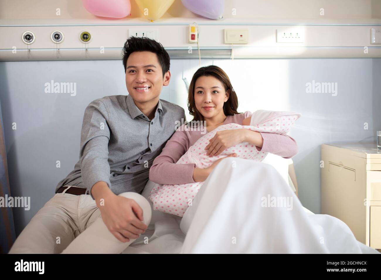 Parents with newborn baby in hospital ward Stock Photo - Alamy
