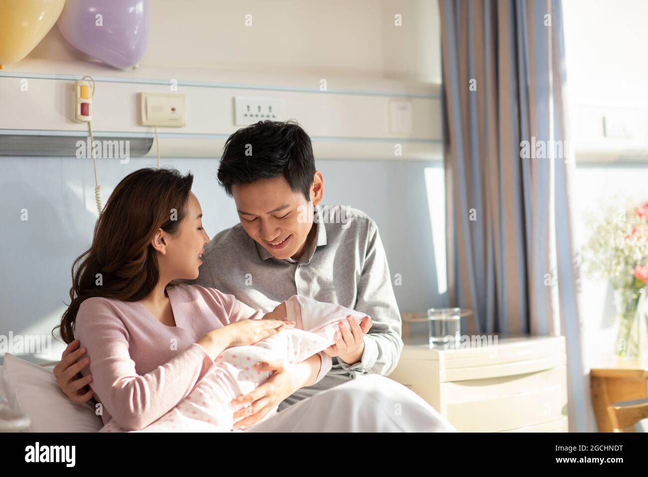 Parents with newborn baby in hospital ward Stock Photo - Alamy