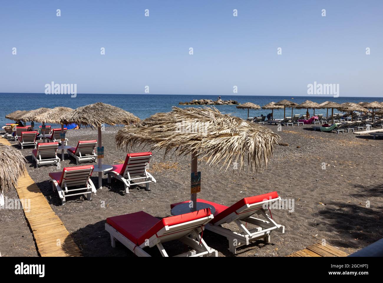 Kamari, Santorini, Greece - June 27, 2021: Sun loungers on the black ...