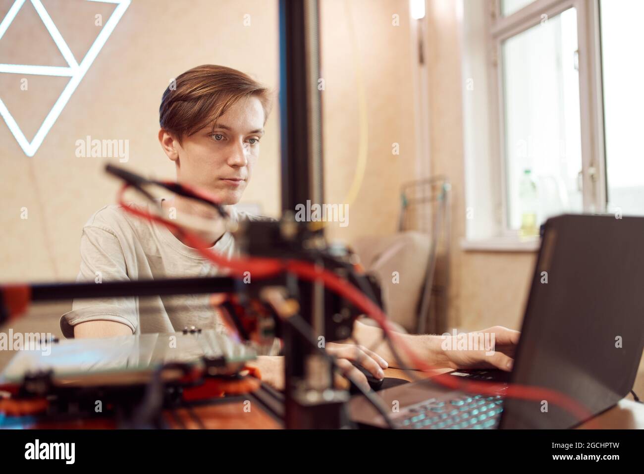 Young man set up 3d printer at home Stock Photo - Alamy