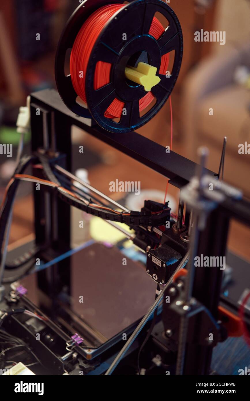 High angle of bobbin with plastic coil attached to modern 3D printer on ...