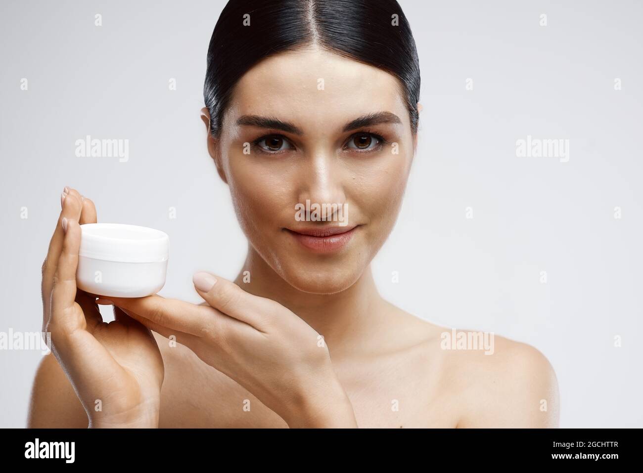 cheerful brunette bathhouse with cream skin care Stock Photo - Alamy
