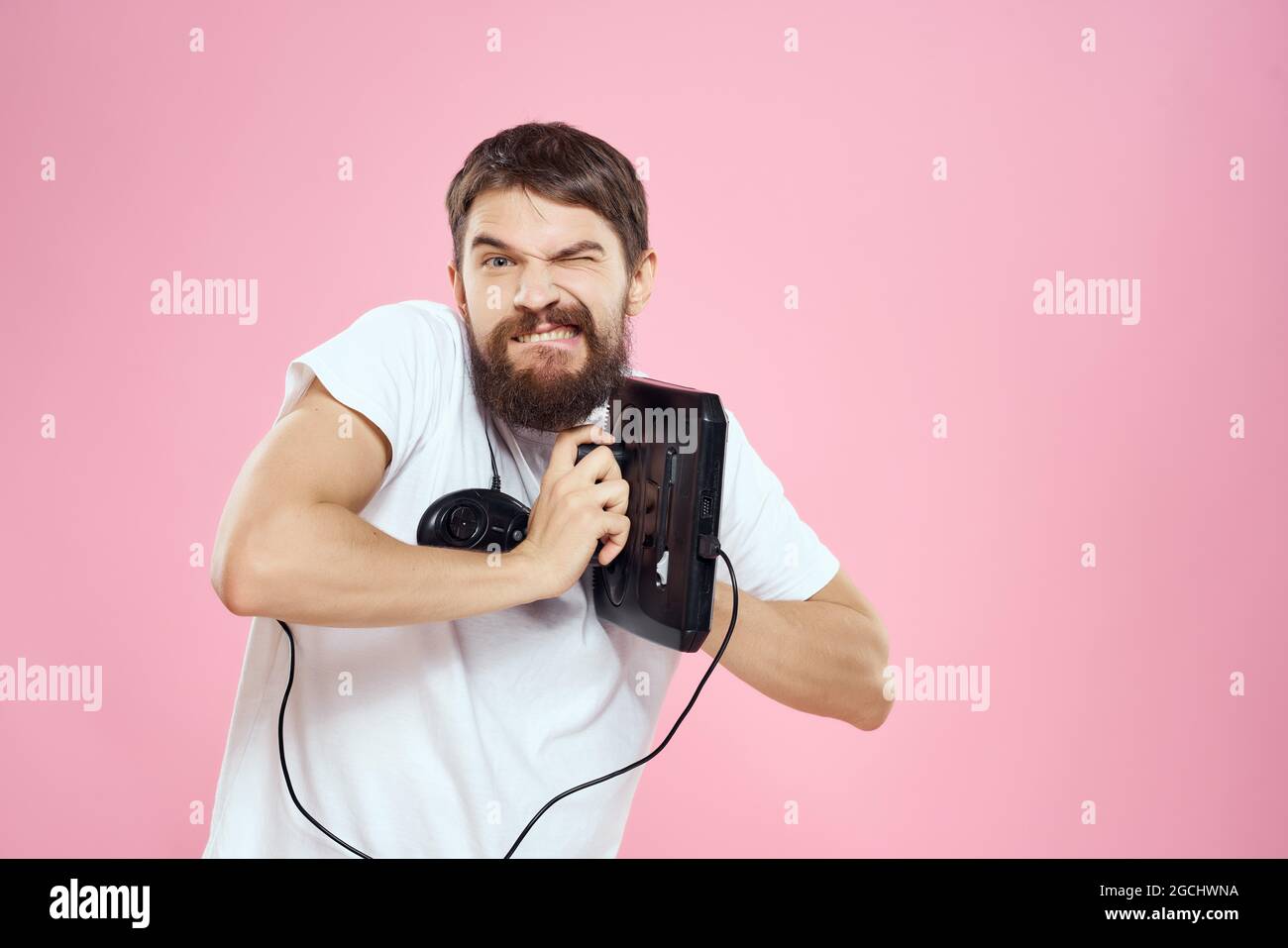 bearded man holding gaming console hands lifestyle technology pink ...