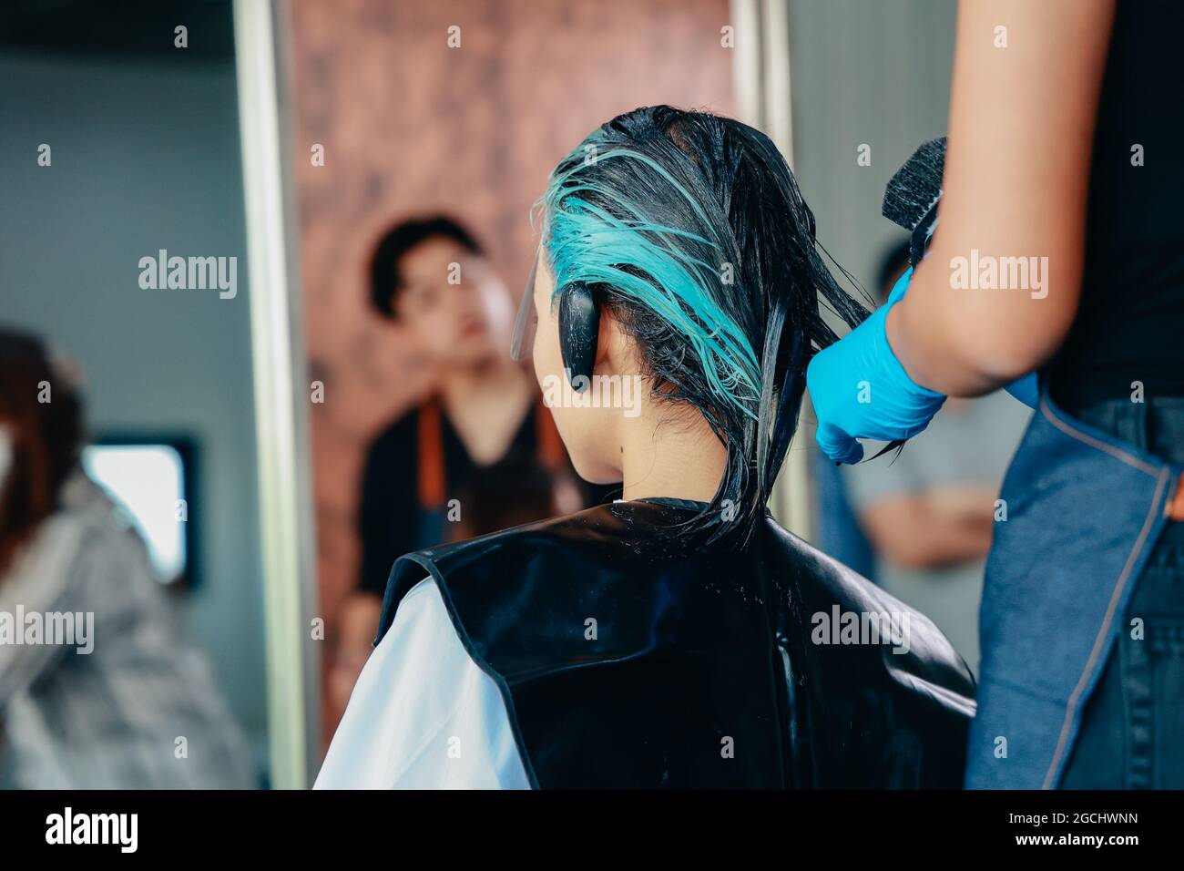 Portrait of young Asian female sitting in modern parlour while getting ...