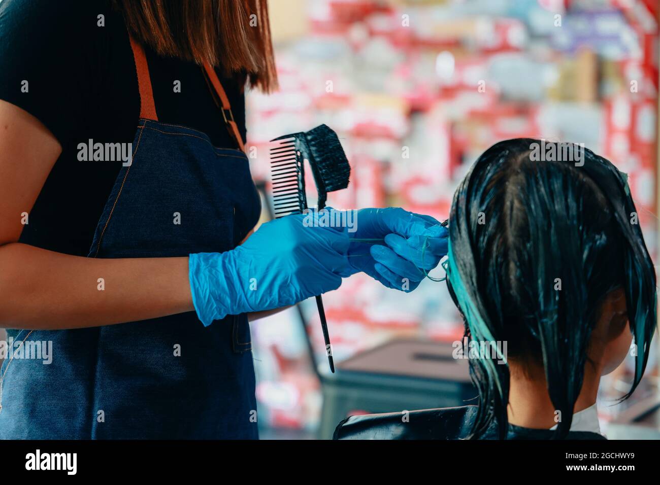 Portrait of young Asian female sitting in modern parlour while getting ...