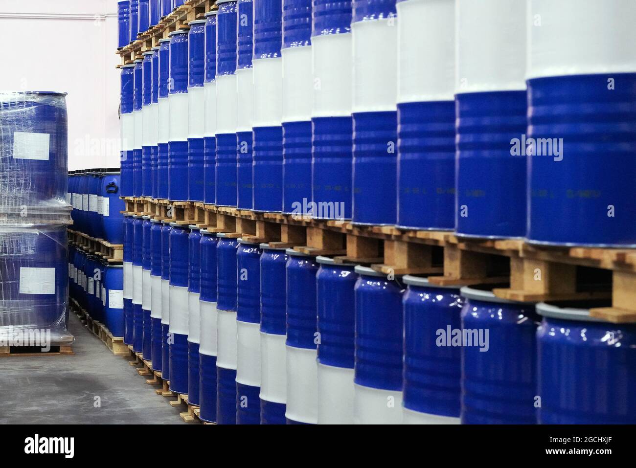 Blue chemical barrels with white stripes line up in chemical storage of ...