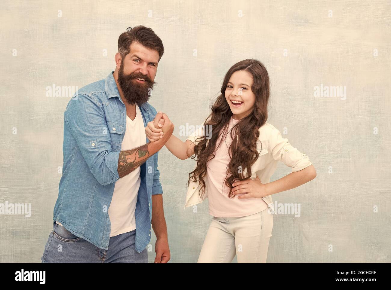 Family is power. Little child and father compete in arm wrestling ...