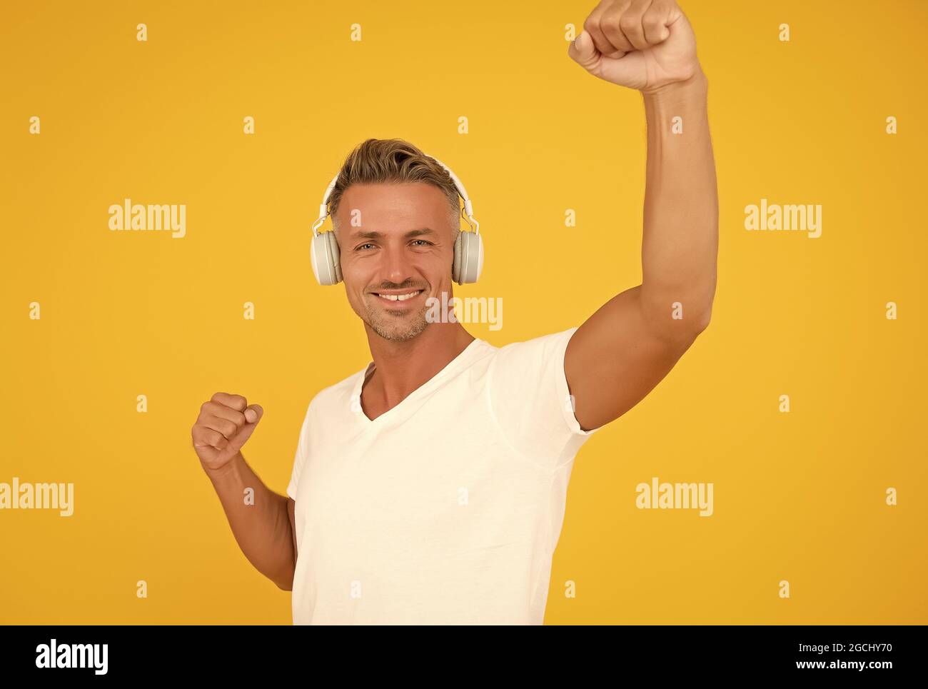 Happy energetic guy listen to music in headphones making winning ...