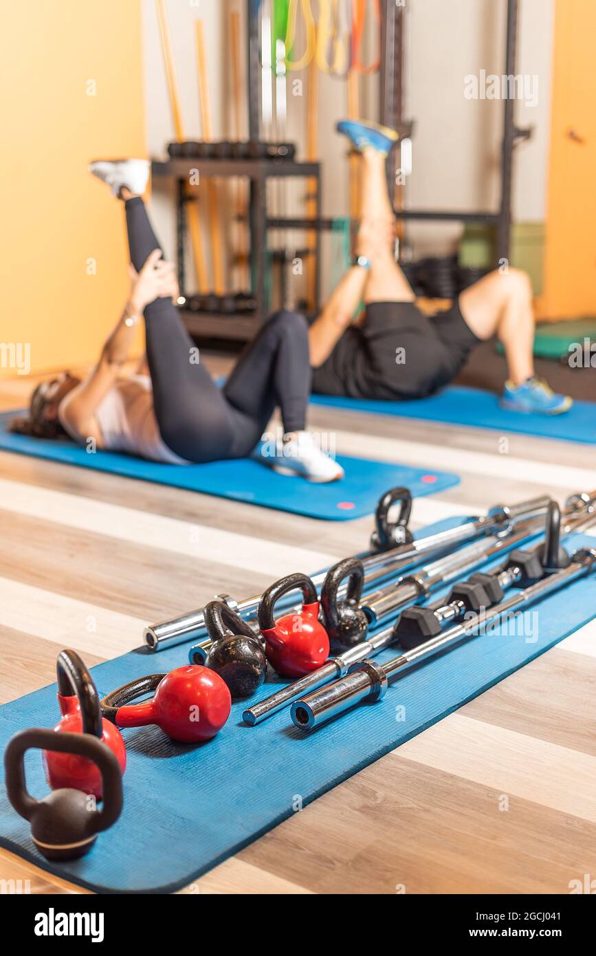 Gym equipment on foam roll while people are stretching their legs in ...