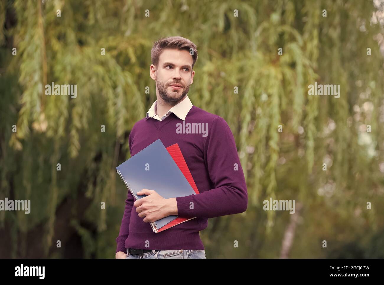 college student guy study with notebook outdoor preparing for exam and ...